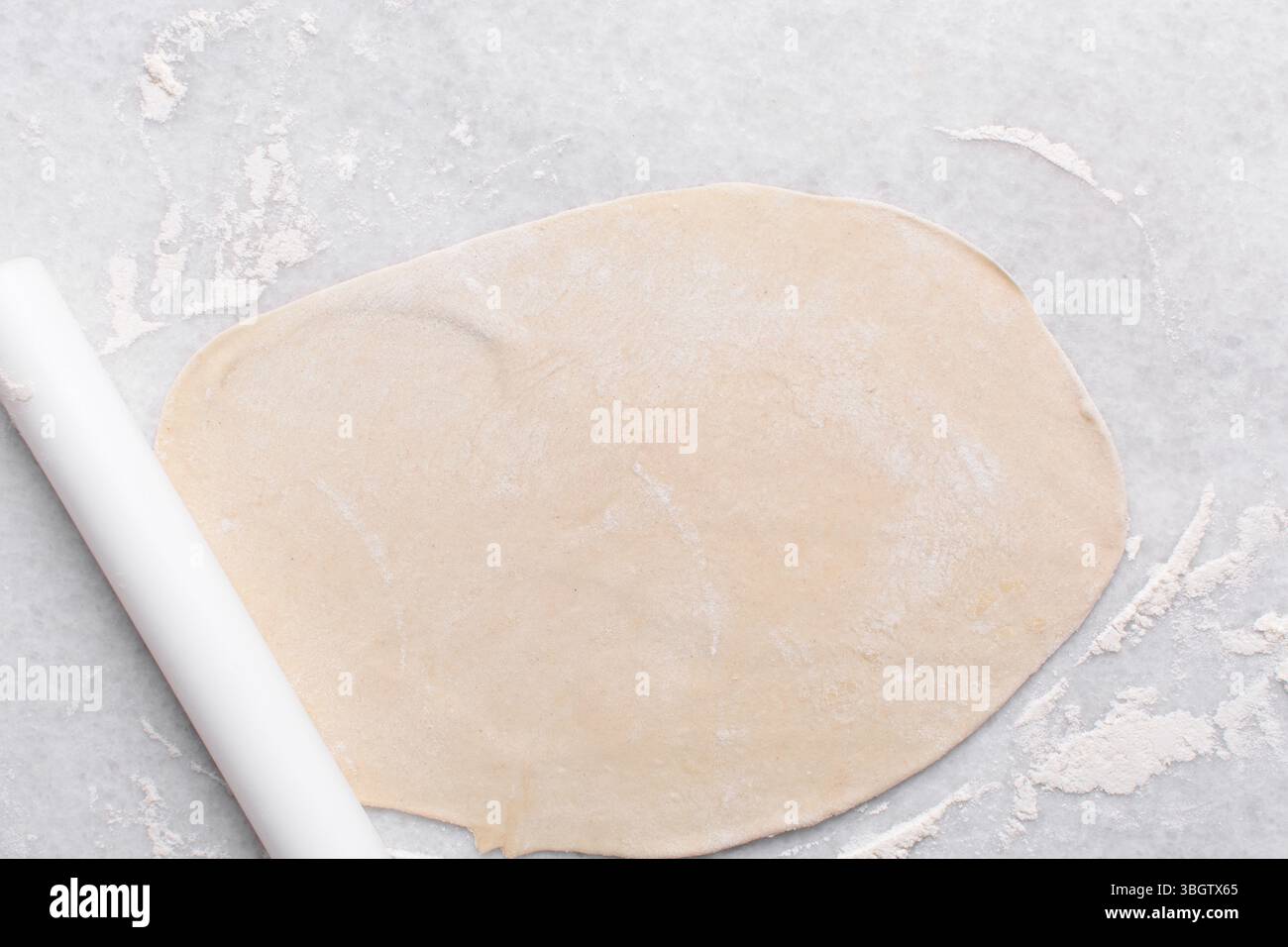 Overhead view of paratha dough being rolled out, top view of flaky ...