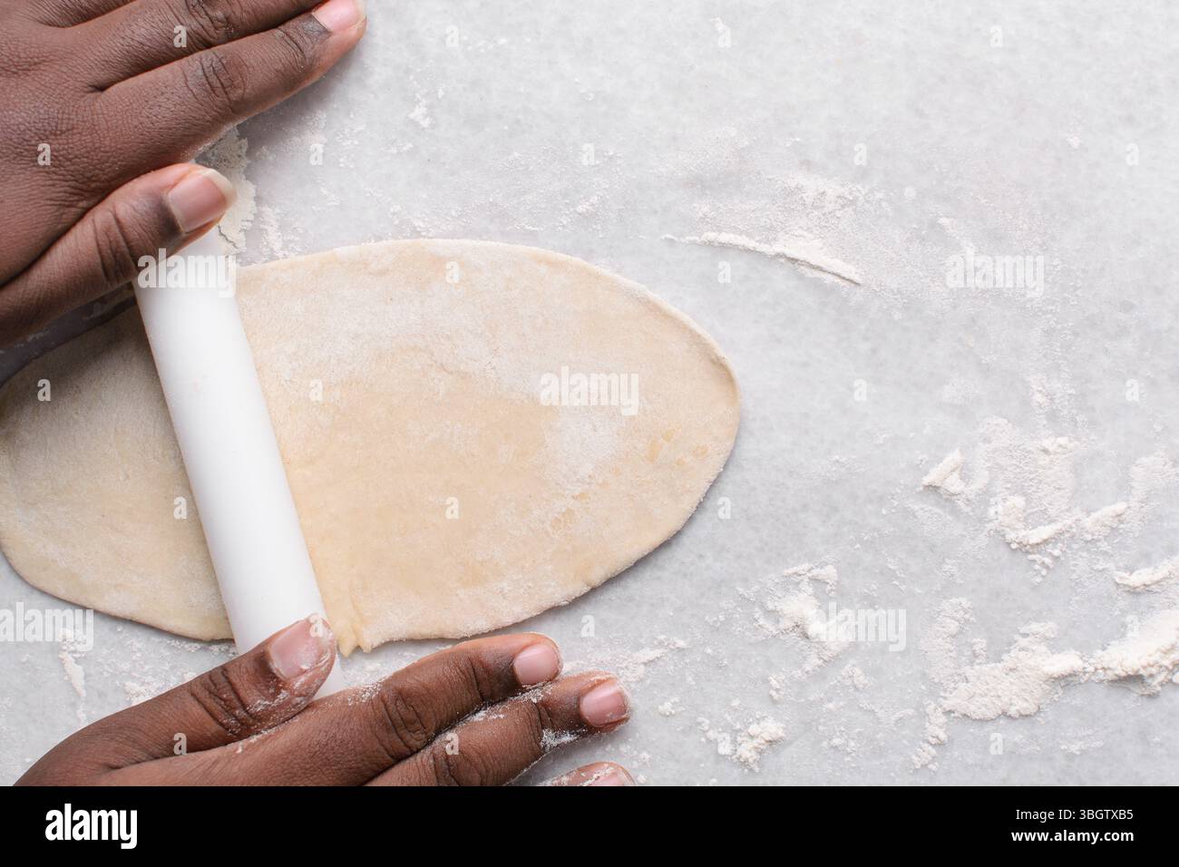 Overhead view of paratha dough being rolled out, top view of flaky ...
