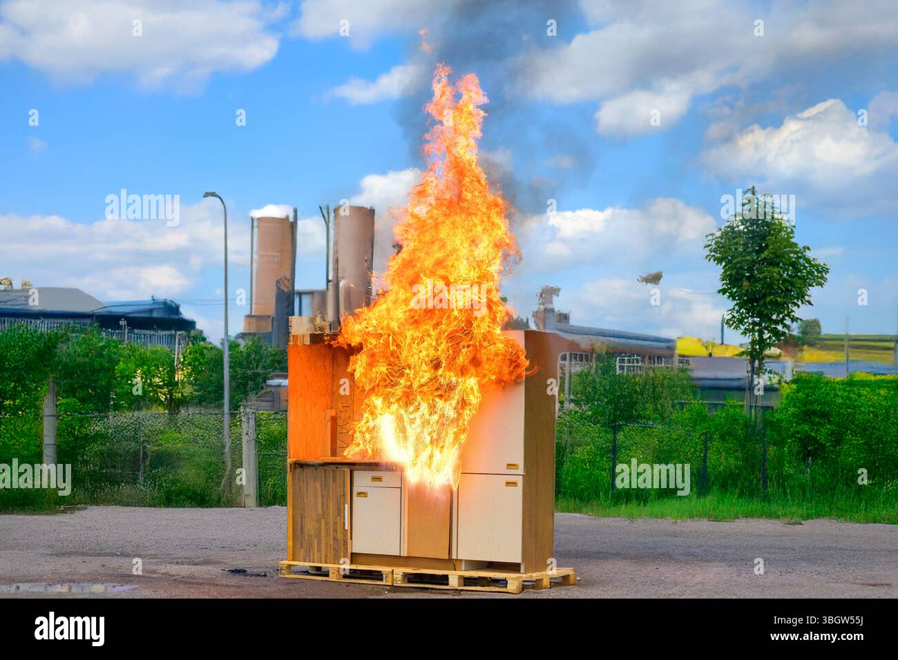 A kitchen unit mounted on a pallet burns intensely during a controlled ...