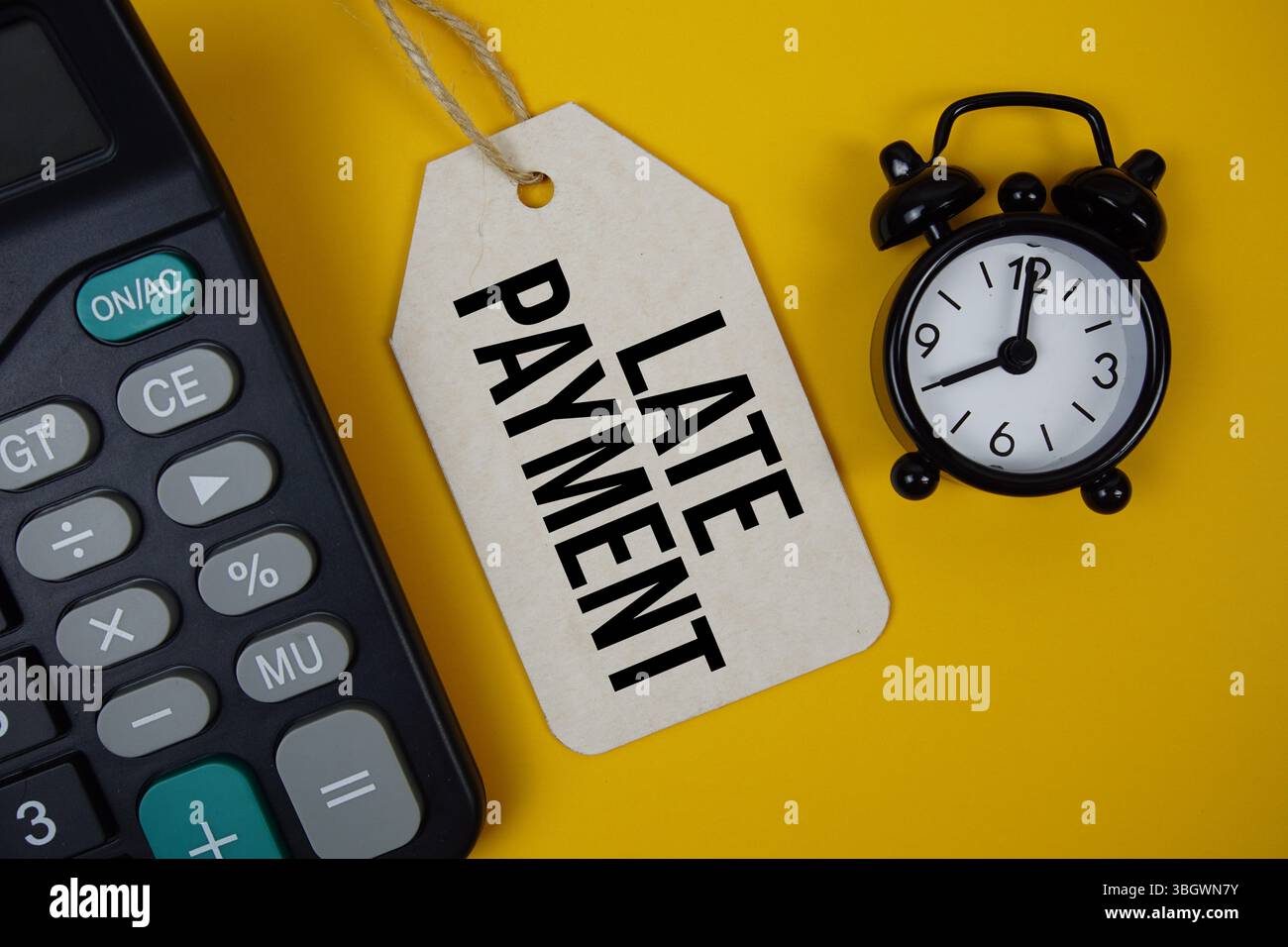 Late Payment text on price tag with alarm clock and calculator on ...