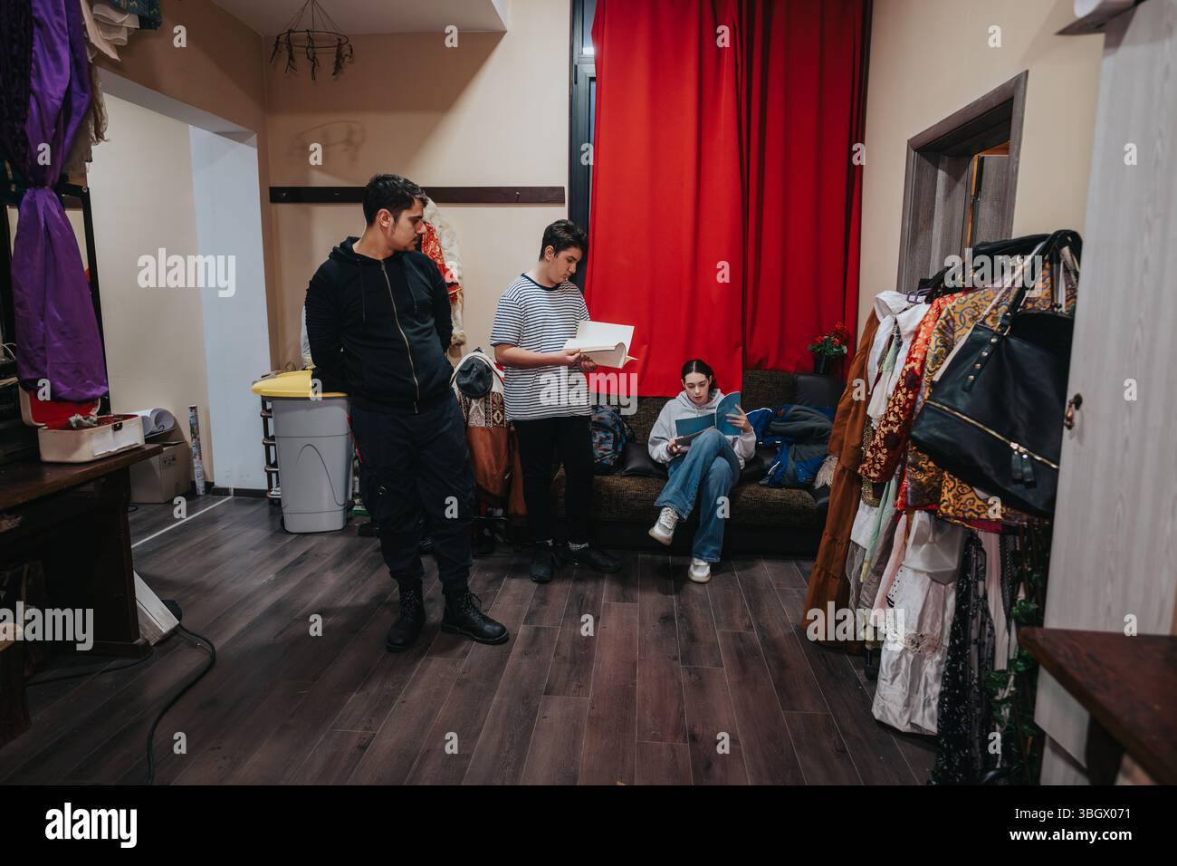 Young actors rehearsing backstage in a theater setting surrounded by ...