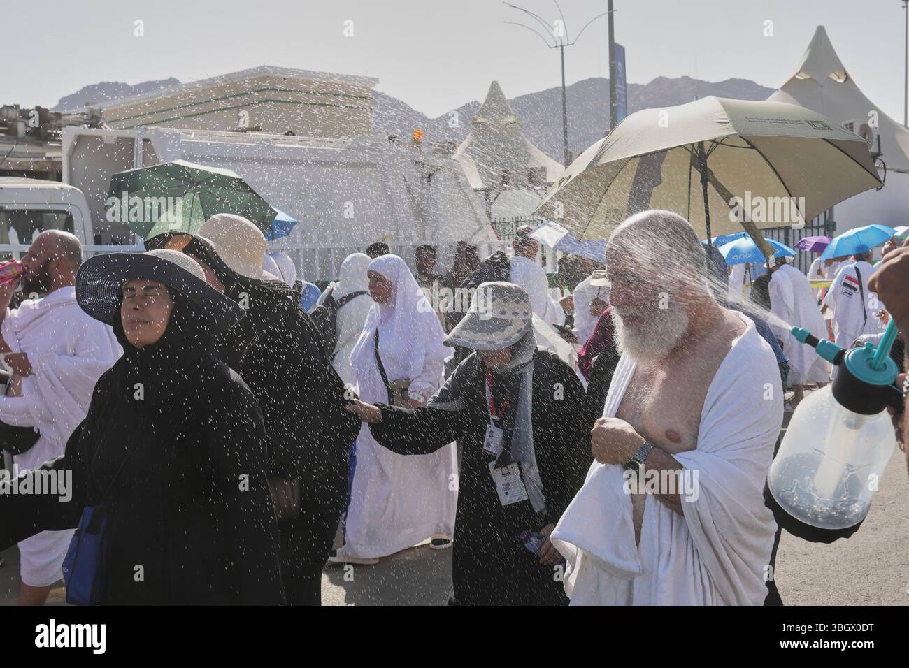 Muslim pilgrims are sprayed by cold water during their way to cast ...