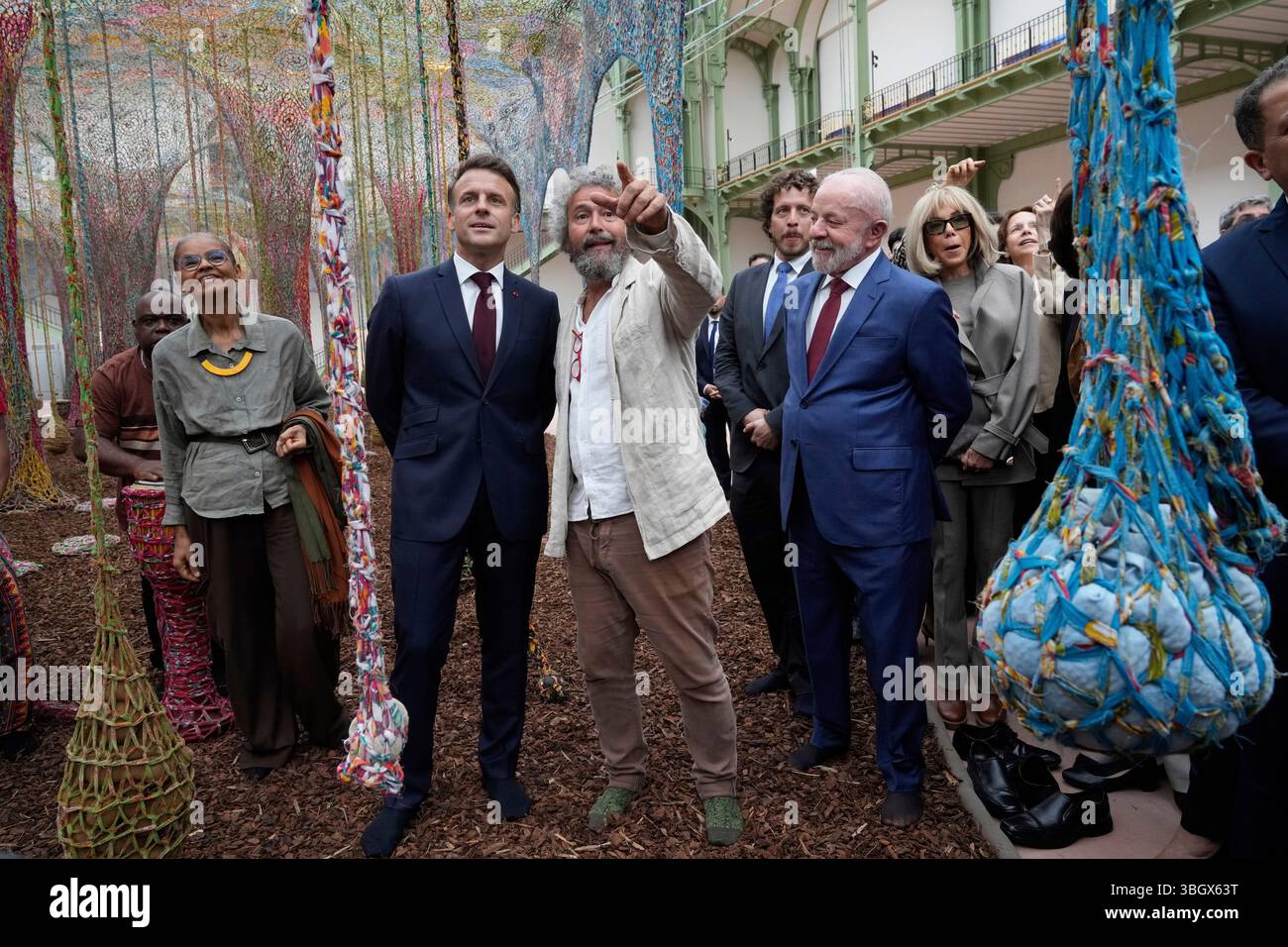 Brazilian artist Ernesto Neto, center, gestures as French President ...