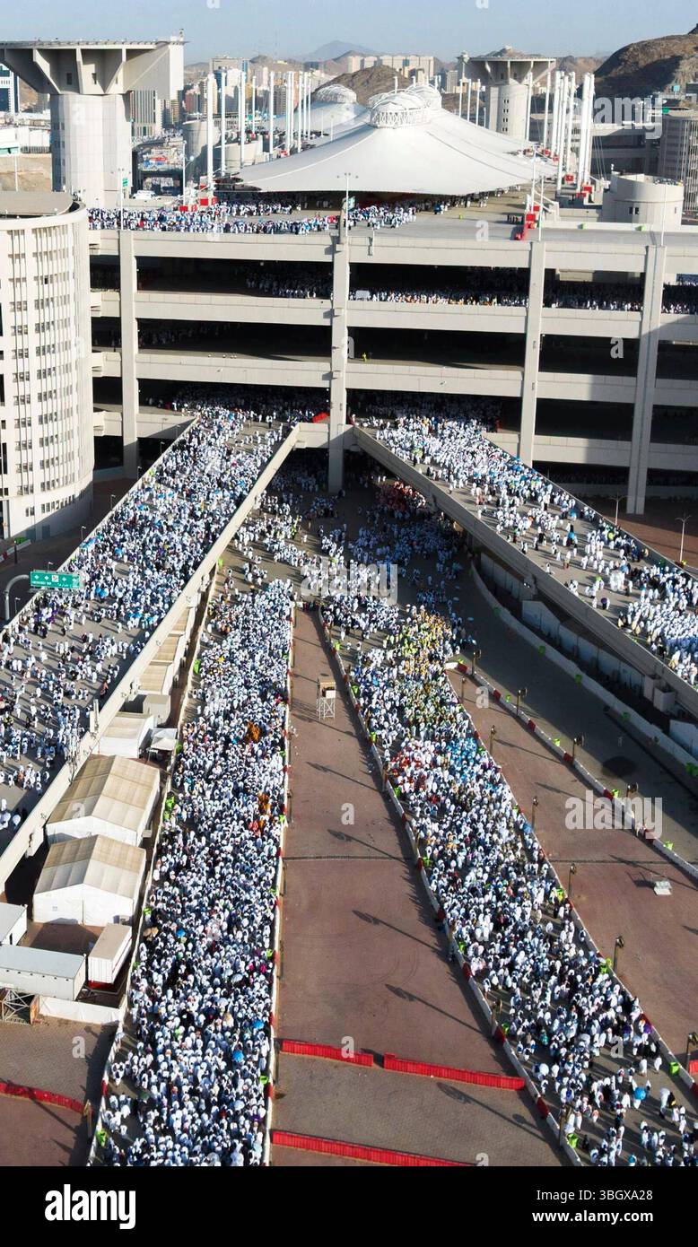 Muslim pilgrims hold umbrellas as they walk to cast stones at pillars ...