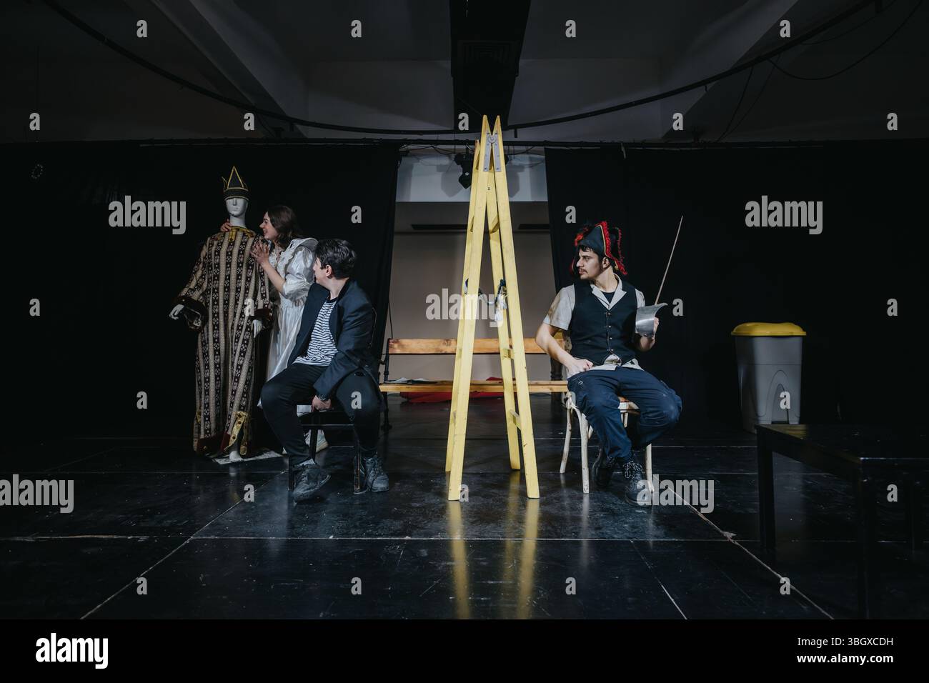 Young actors performing a theatrical scene on a stage with dramatic ...