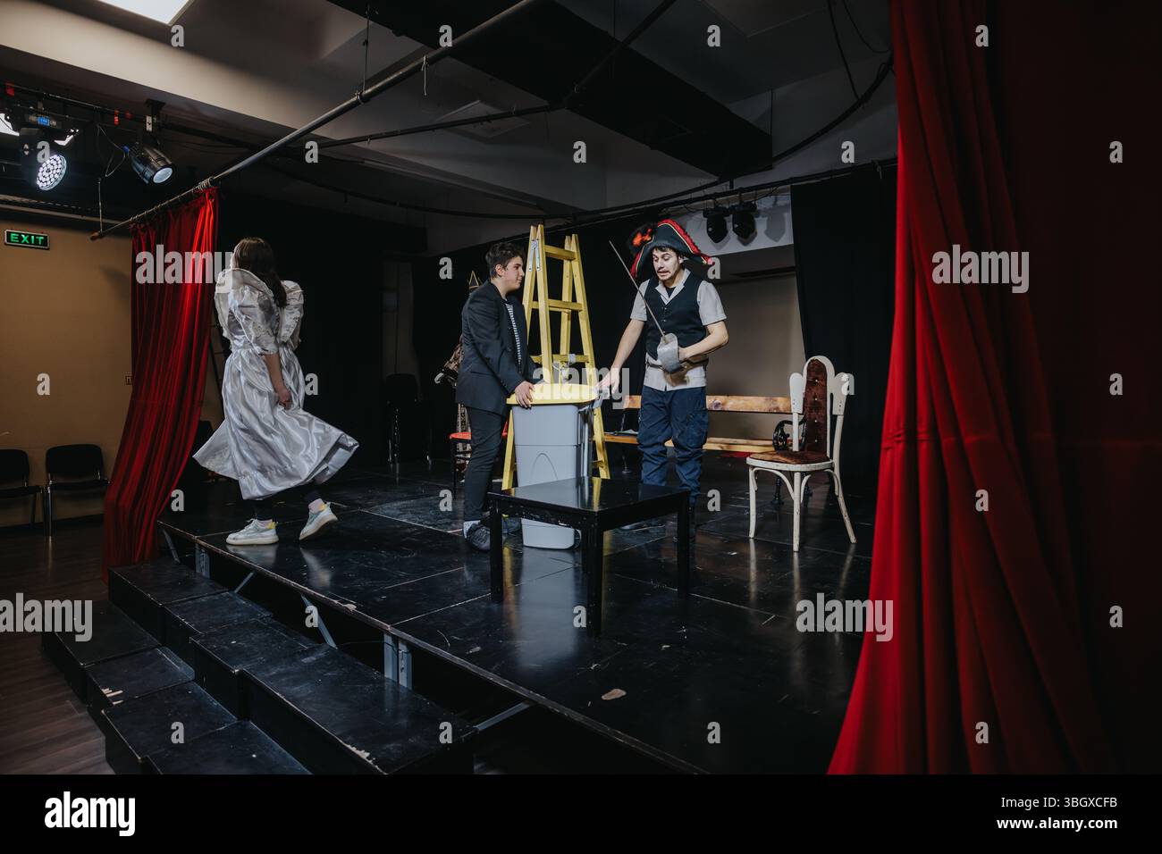 Young actors rehearse on a theater stage with costumes and props Stock ...