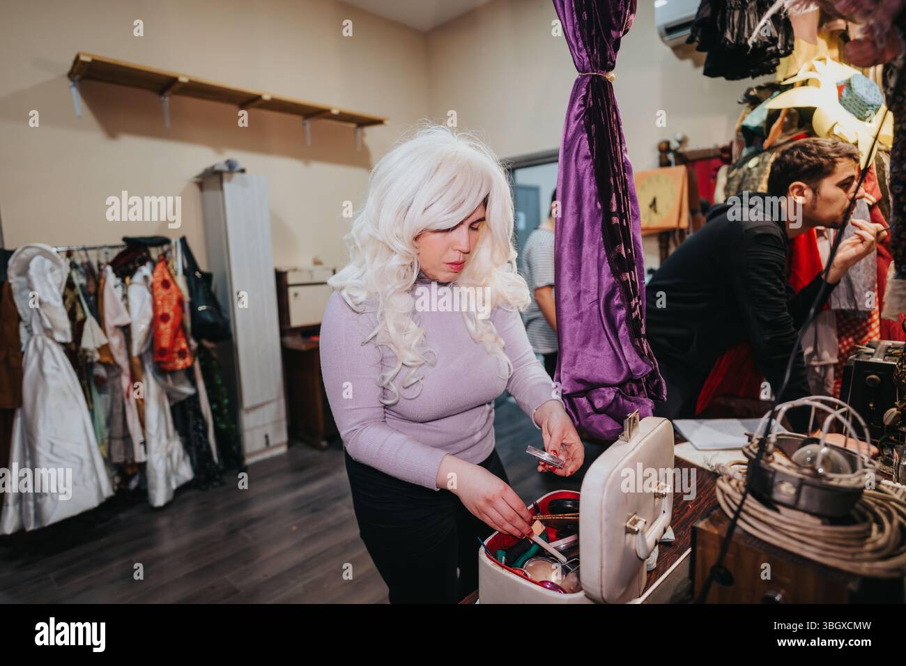 Actors preparing with costumes and makeup backstage at a theater ...