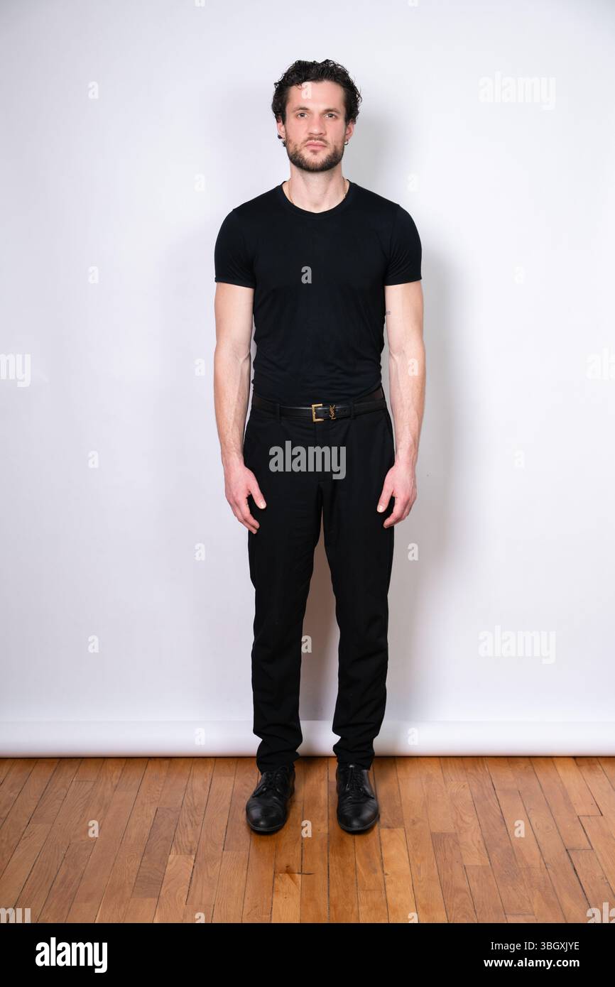 A full-length studio shot of a man, who appears to be of Caucasian descent with dark hair and a ...