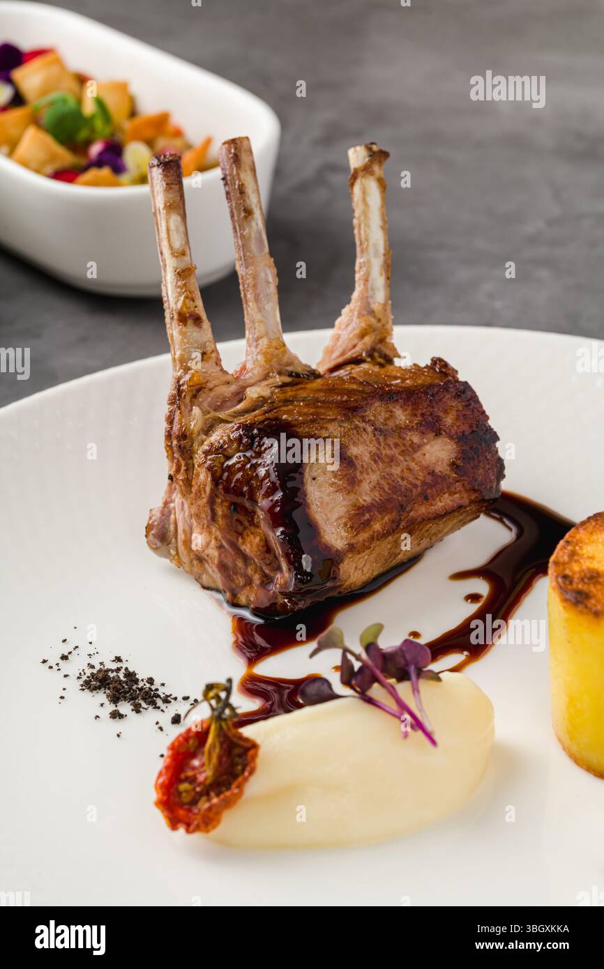 Grilled lamb chops with mashed potato, polenta cake and garnish Stock ...