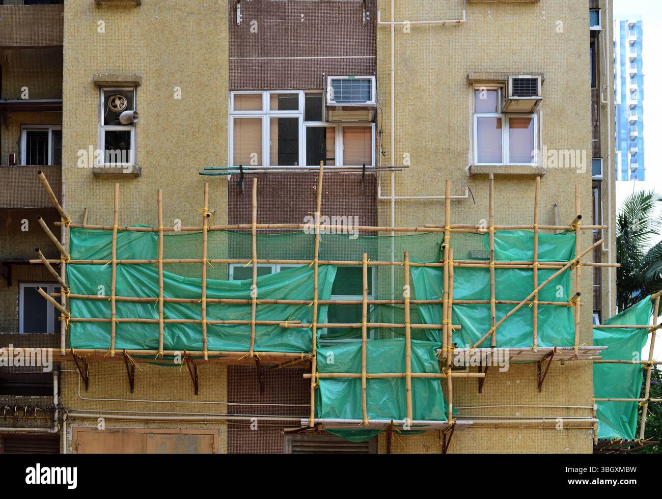 Bamboo scaffolding platforms mounted outside a building for repairing ...
