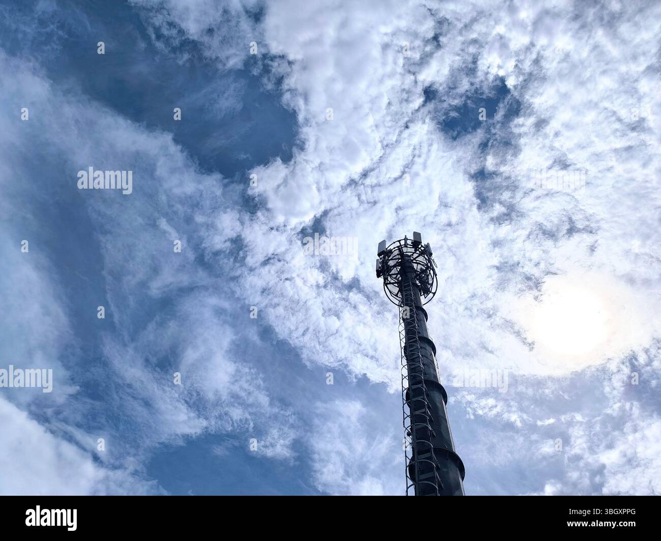 Telecommunication tower stands tall with a backdrop of bright white ...
