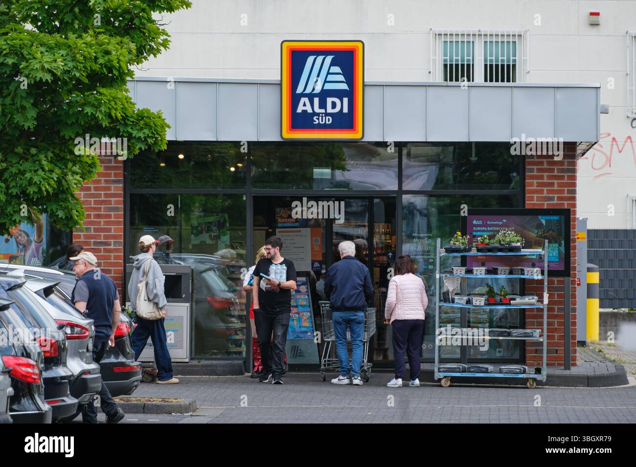 People enter and exit ALDI Süd store with groceries and carts Stock ...