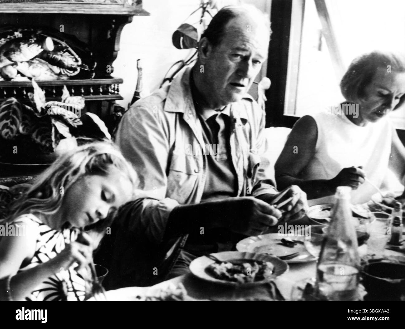 Actor John Wayne with his wife and their daughter Aissa enjoy a meal ...
