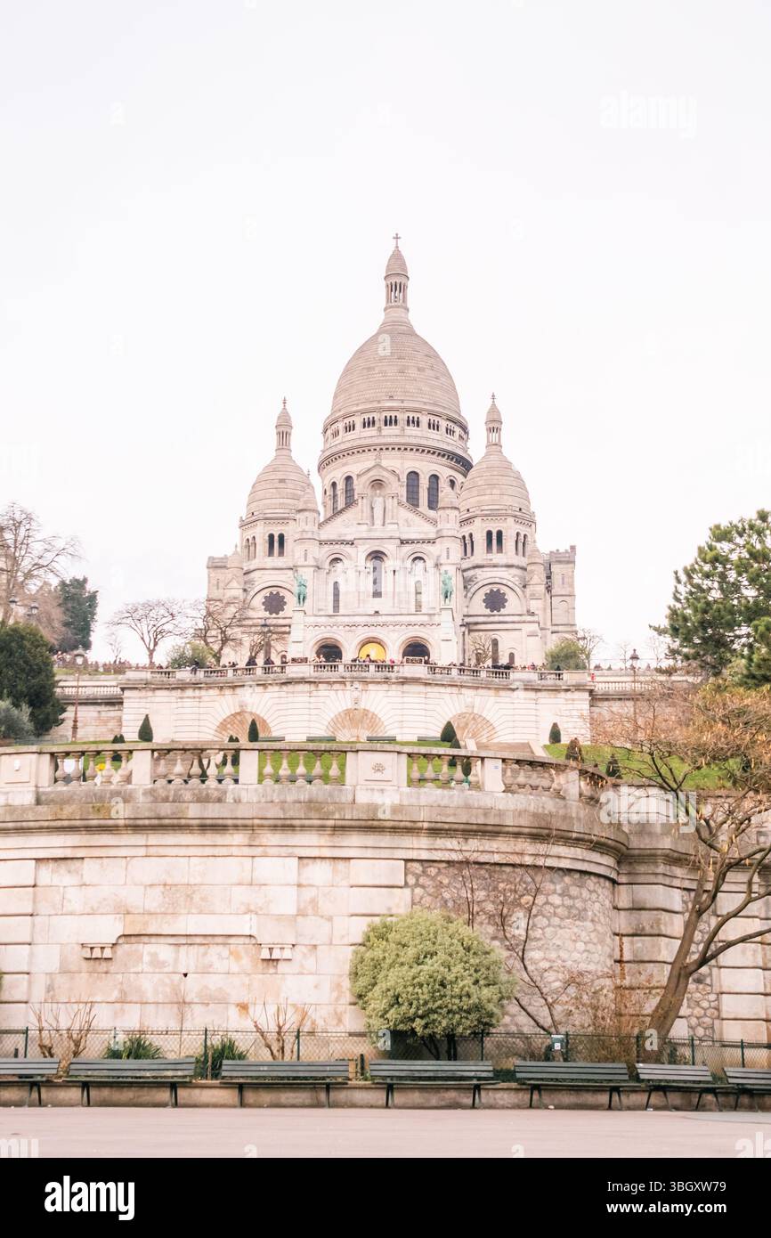 A frontal view of a grand, white stone basilica with multiple domes ...