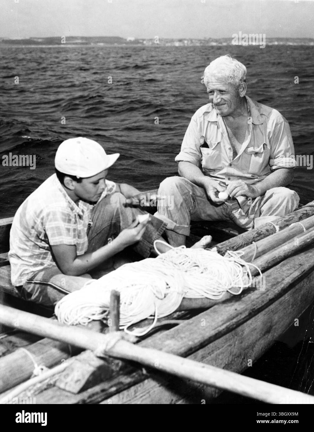 Veteran movie actor Spencer Tracy works on fishing lines at sea with ...