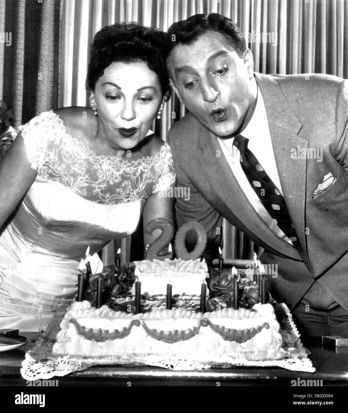 Comedian Danny Thomas and his wife Rosemary blow out candles on a cake ...