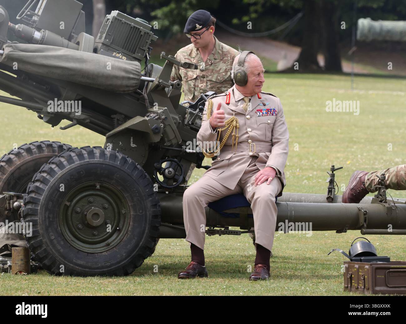 King Charles III reacts after firing an artillery piece during his ...