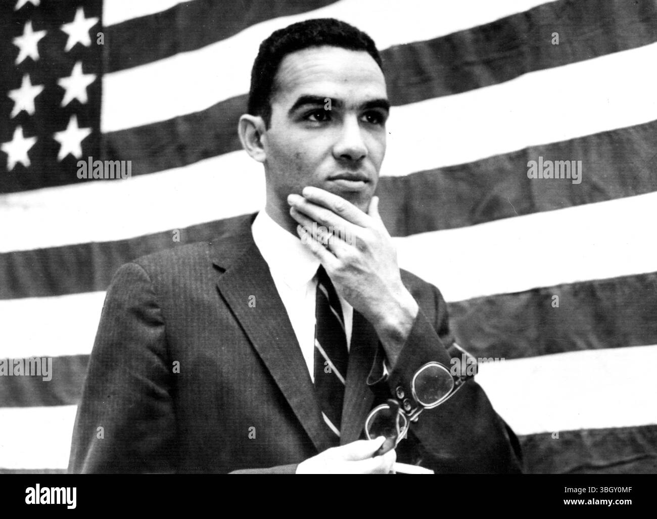 With the American flag as a backdrop, Russell, B. Sugarmon. Jr. waits ...