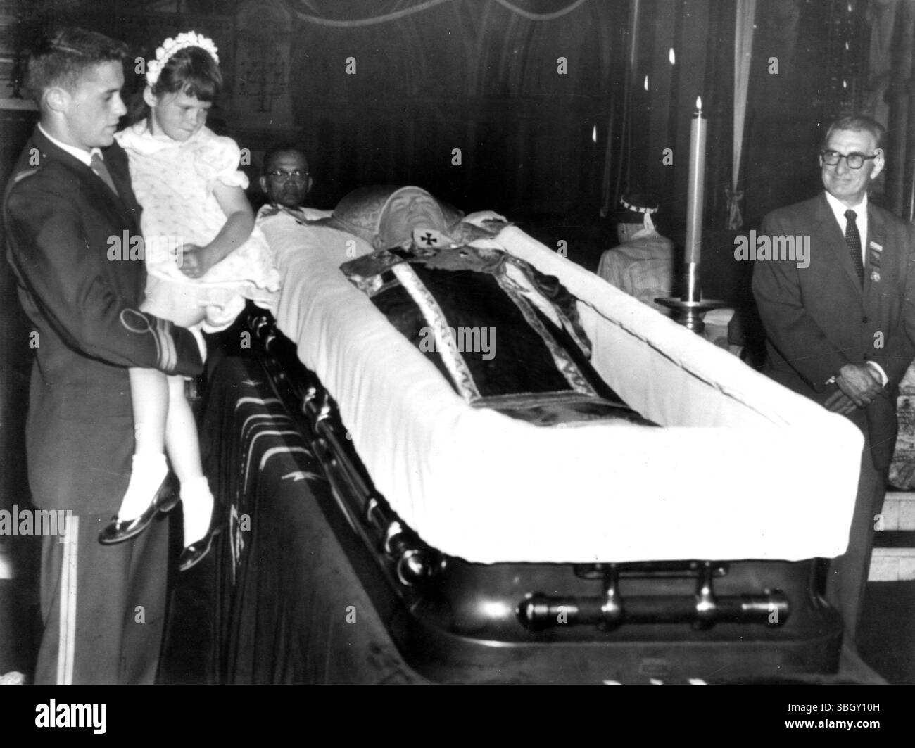 An usher in Holy Name Cathedral holds up Mary Kay Mcdonald,6, and she ...