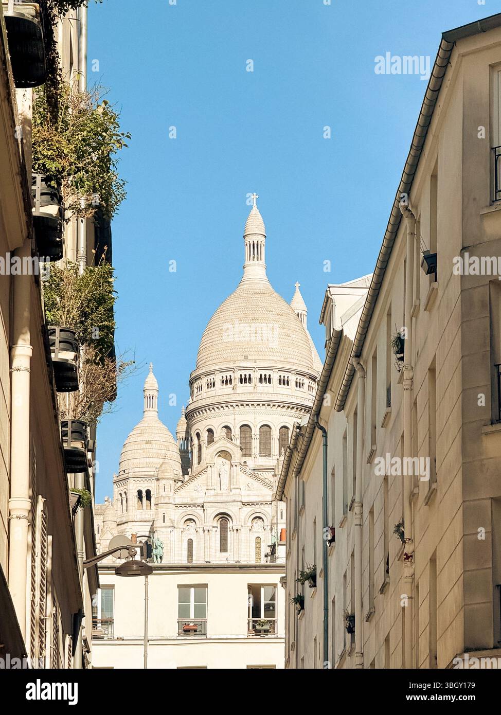 The iconic white domes of a famous Parisian basilica are framed between ...