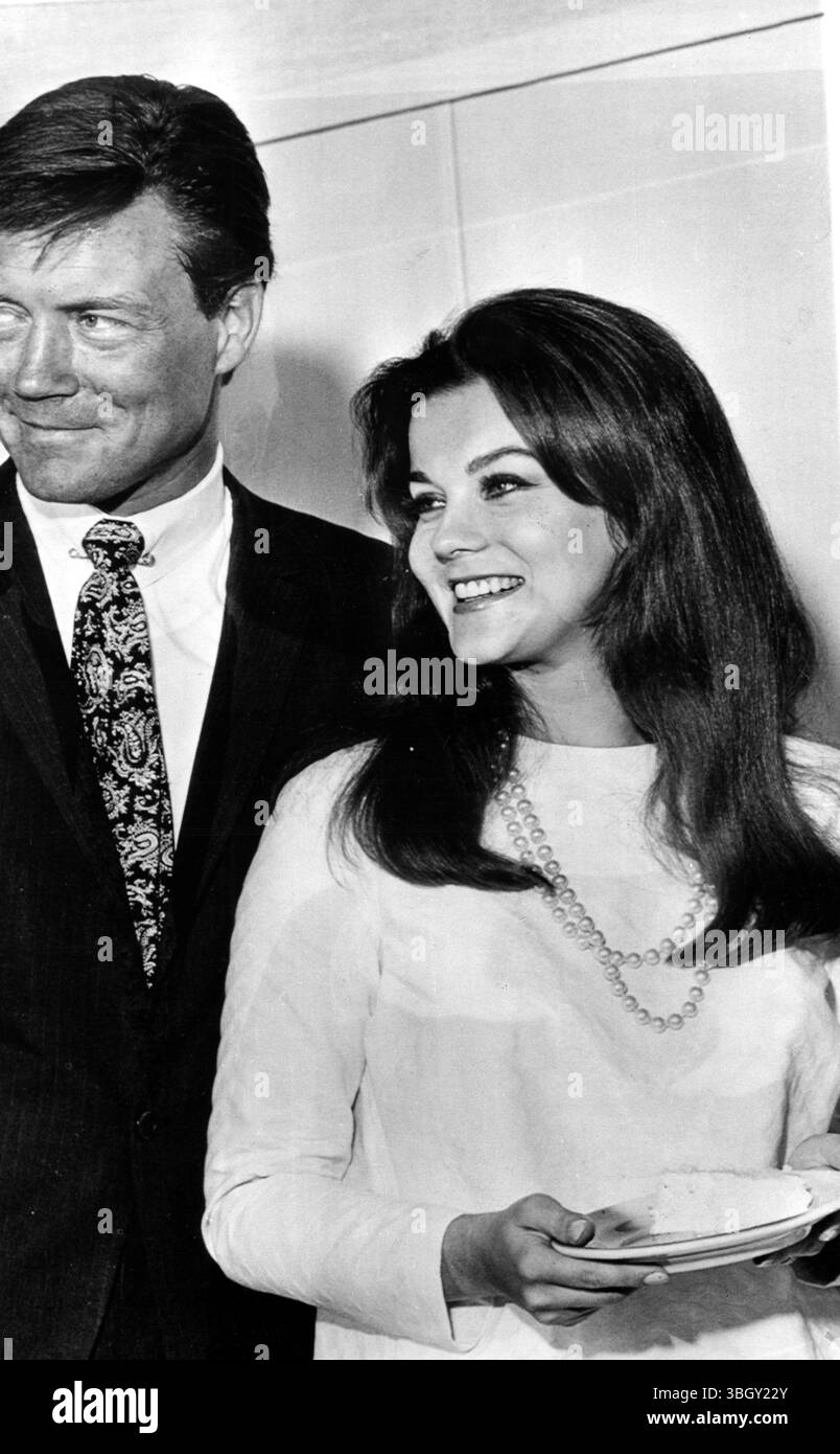 Actress Ann-Margret holds a piece of wedding cake as she stands beside ...