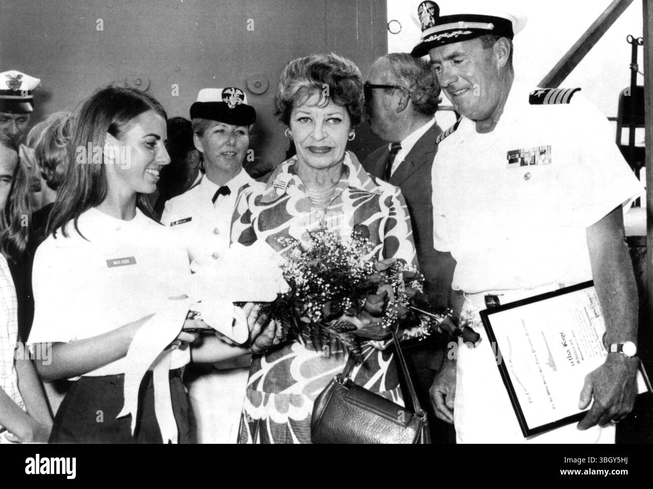 Comedian Martha Raye (centre) receives a bouquet of roses from Nancy ...