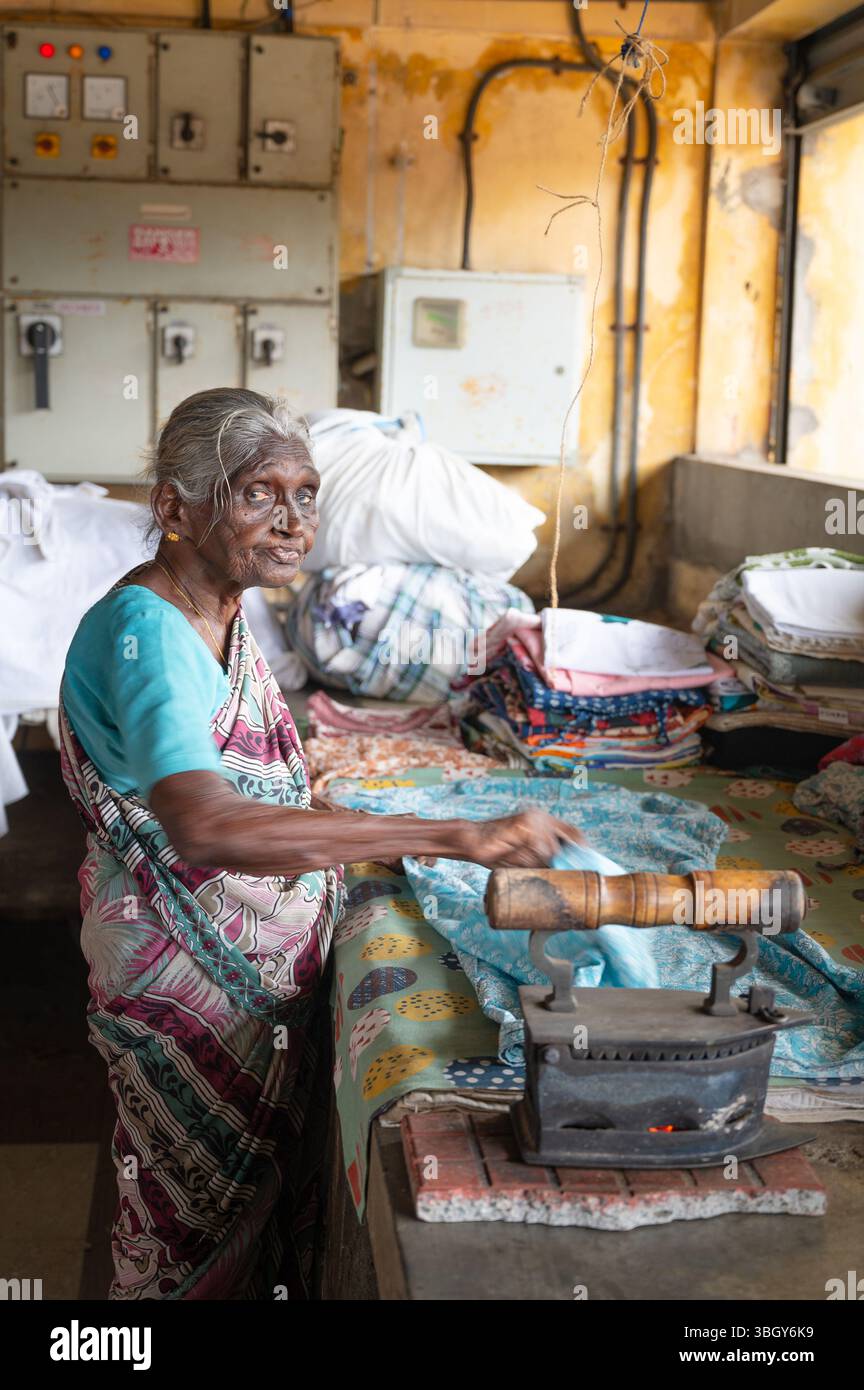 Elderly Woman In Traditional Dress Ironing With An Antique Charcoal ...
