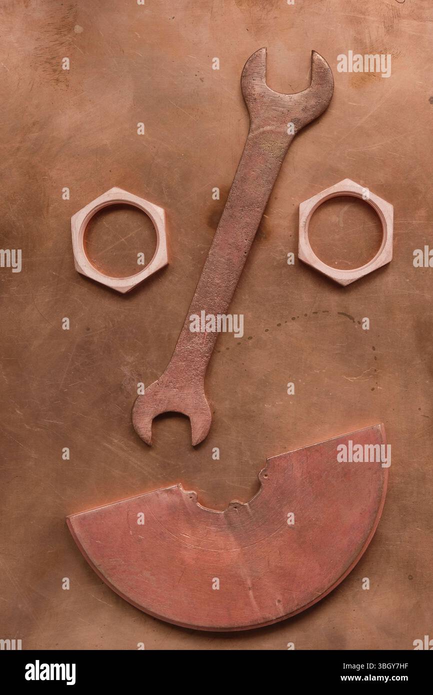 Funny copper face made of copper tools on a copper background. The eyes ...