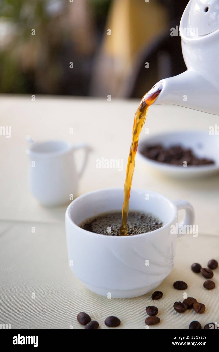 Americano coffee with coffee beans in white cup Stock Photo - Alamy