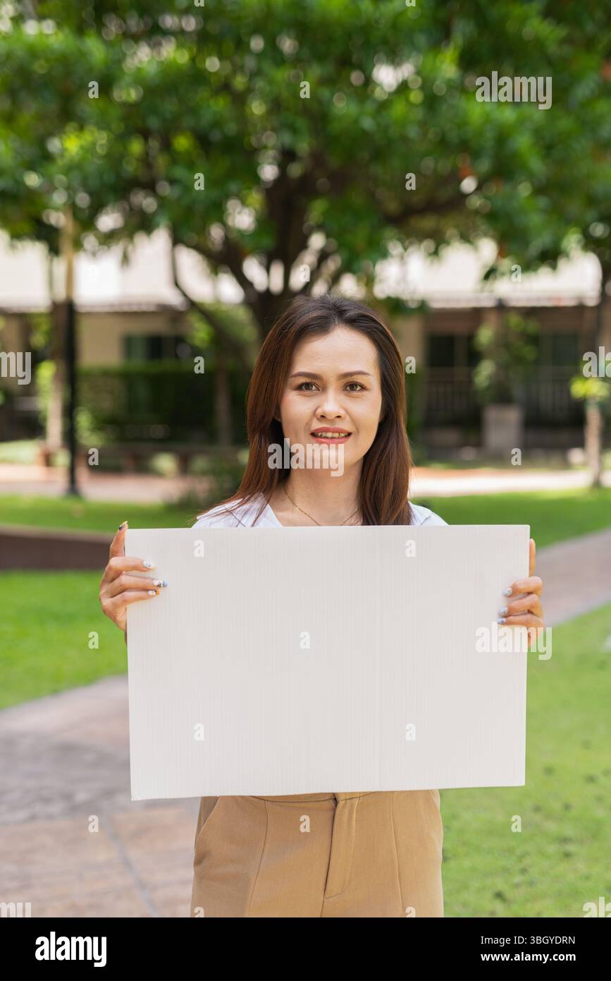 Portrait of beautiful Asian businesswoman in park holding placard Stock ...