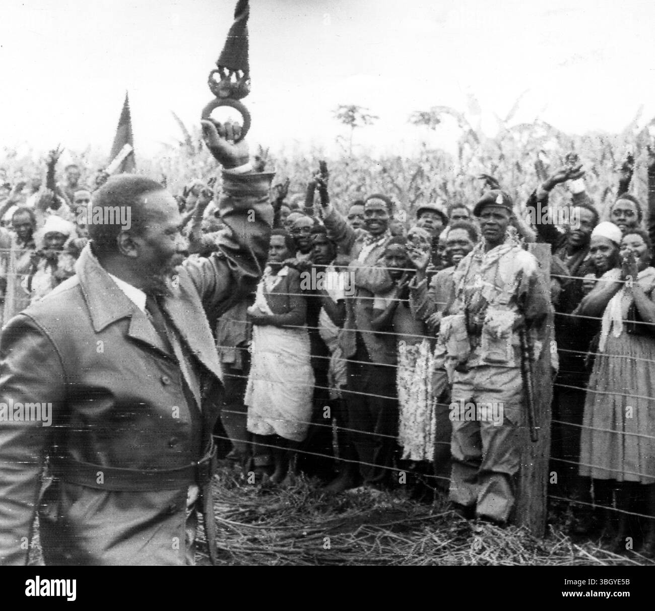 Jomo Kenyatta waives his traditional staff to the jubilant crowds ...