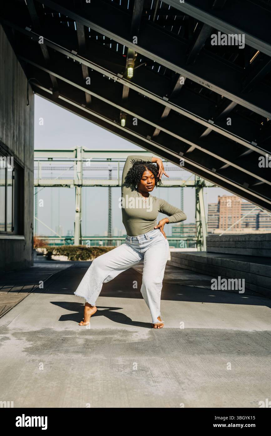 Dancer in graceful pose under urban industrial ceiling structure Stock ...