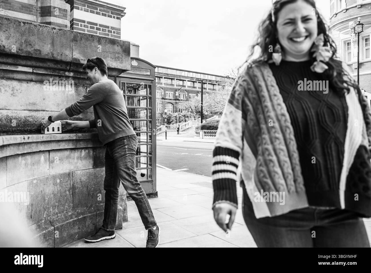 Man places model house near booth as woman walks smiling Stock Photo ...