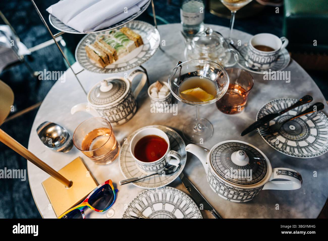 Elegant afternoon tea setup with sandwiches, teapots, and drinks Stock ...