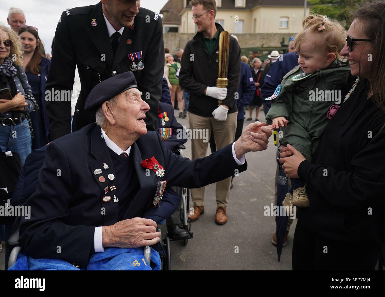 D-Day veteran Henry Rice meets a young girl following a service of ...
