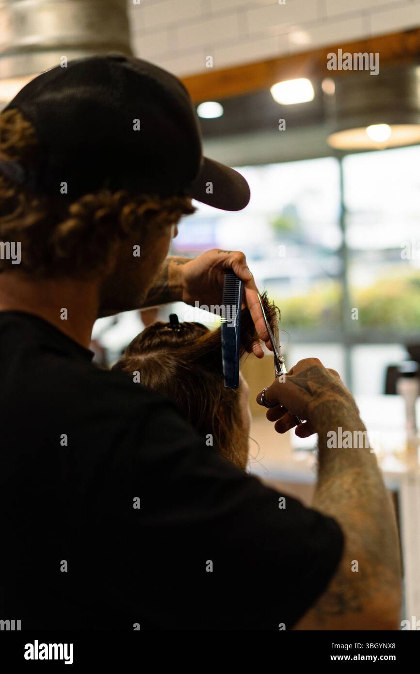 Barber in cap cuts hi-res stock photography and images - Alamy