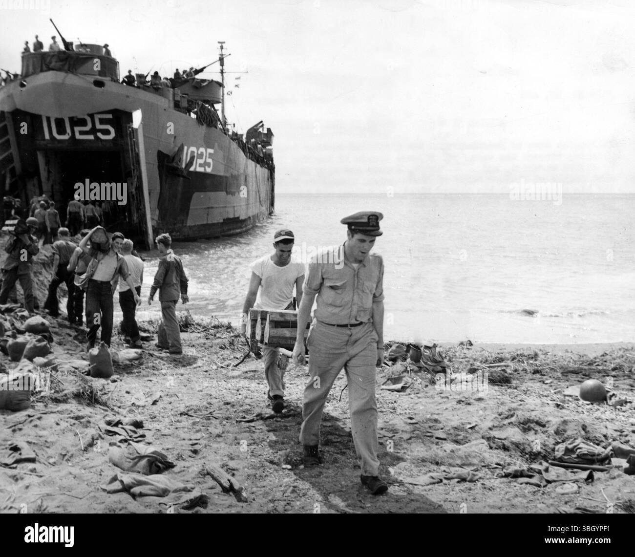 An LST ( Landing Ship , Tank ) with bow doors open unloads on the beach ...