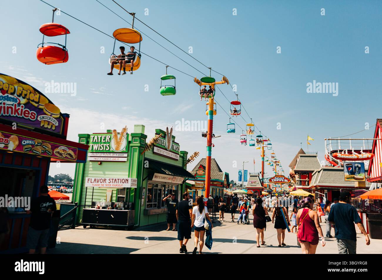 Crowds and colorful sky ride at lively Santa Cruz Beach Boardwalk Stock ...