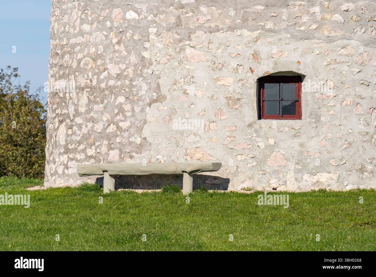 Old wooden bench in front of a medieval stone windmill Stock Photo - Alamy