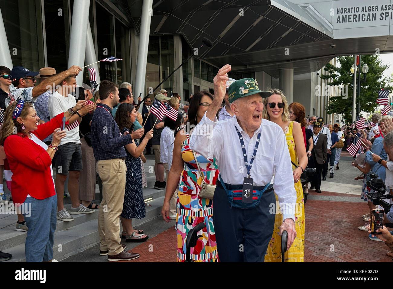 World War II veteran James Deal waves at a crowd cheering on war heroes during the National ...