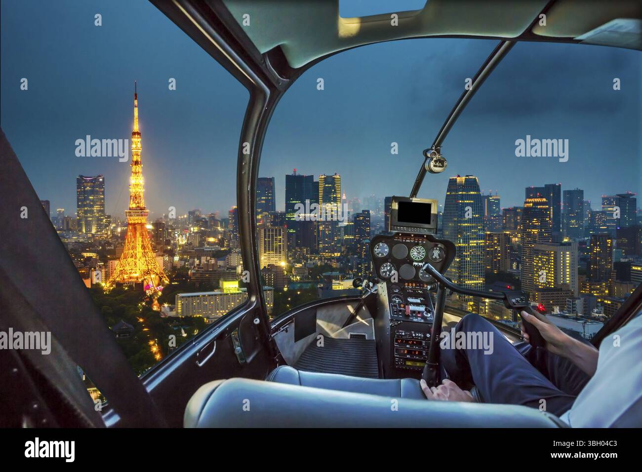 Helicopter flying on Tokyo Skyline at dusk with illuminated Tokyo Tower ...