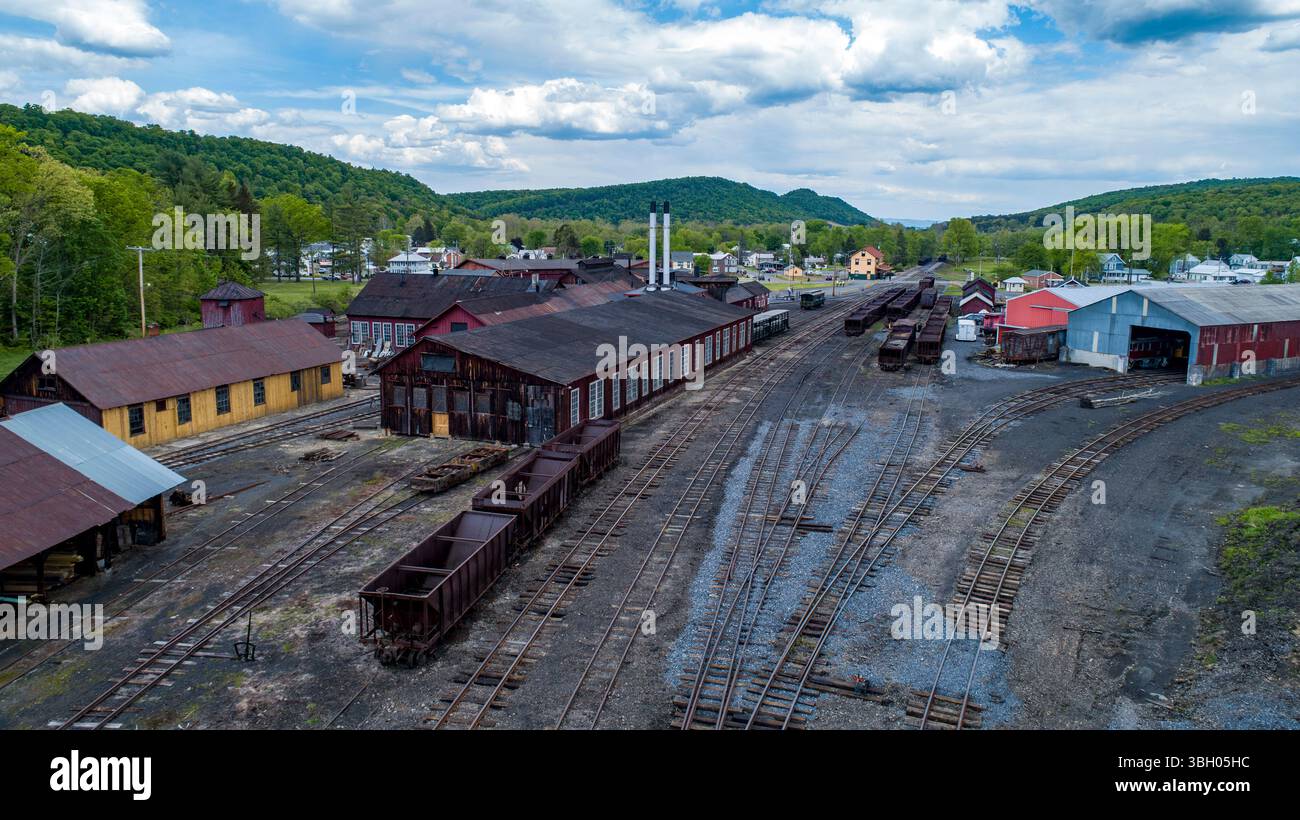 A rail yard in a small town features vintage buildings and numerous ...