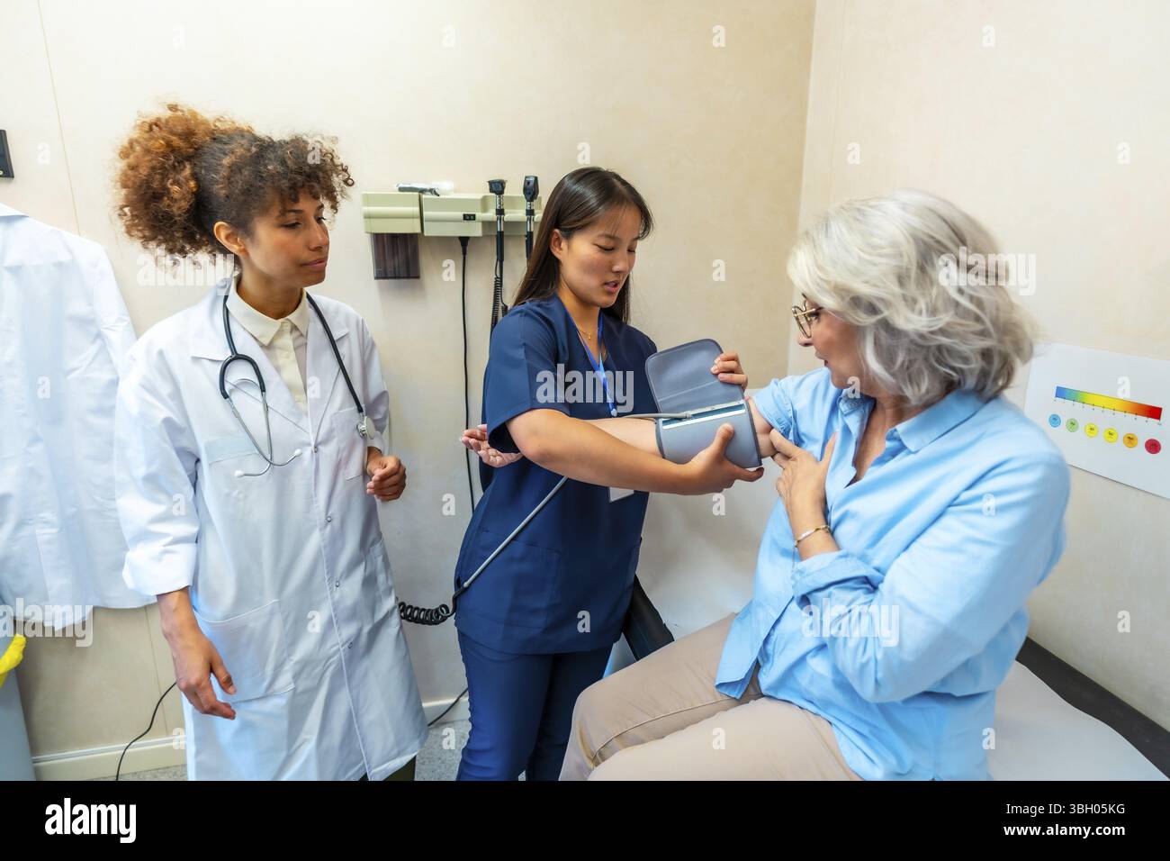 Nurse taking blood pressure of elderly woman during medical check up ...