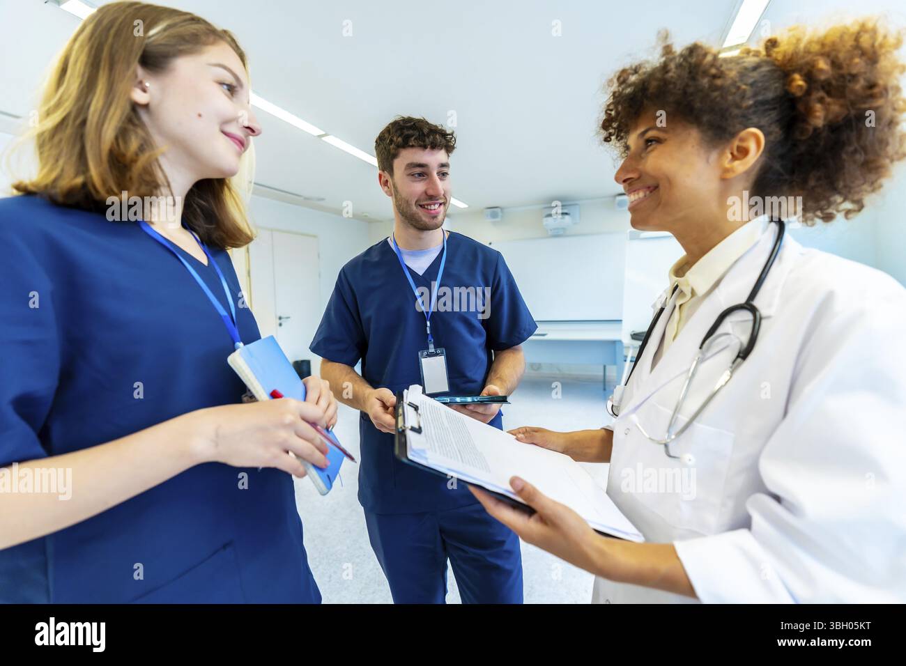 Doctor and nurses reviewing medical records, collaborating on patient ...
