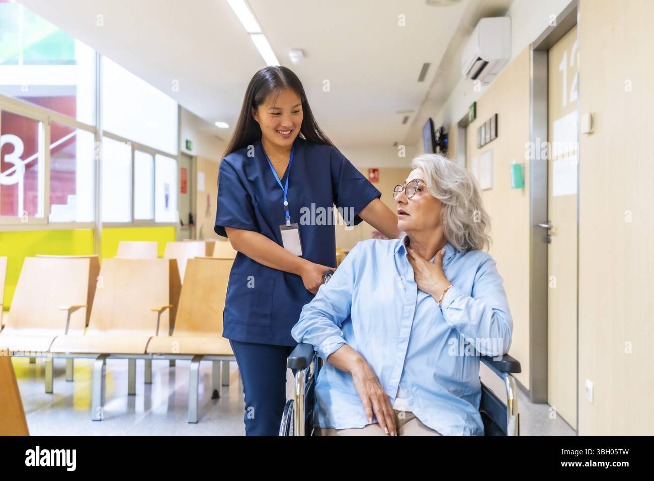 Young nurse supporting elderly woman experiencing respiratory problems ...