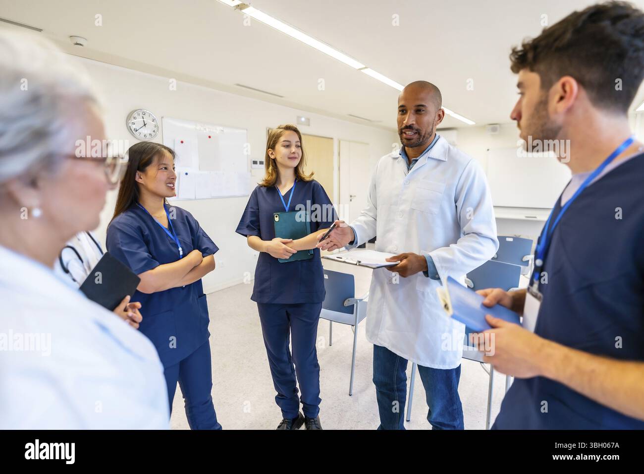 Doctors and nurses participating in a medical briefing, exchanging ...