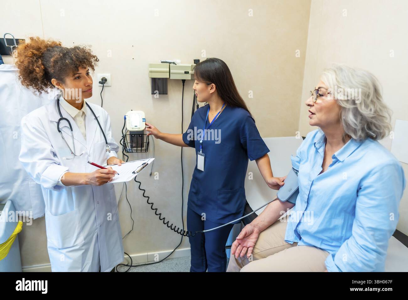 Medical professionals taking care of elderly woman's health, performing ...