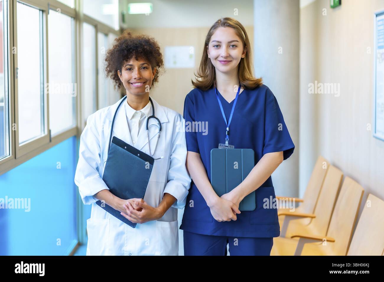 Doctor and nurse smiling while holding medical records in a hospital ...
