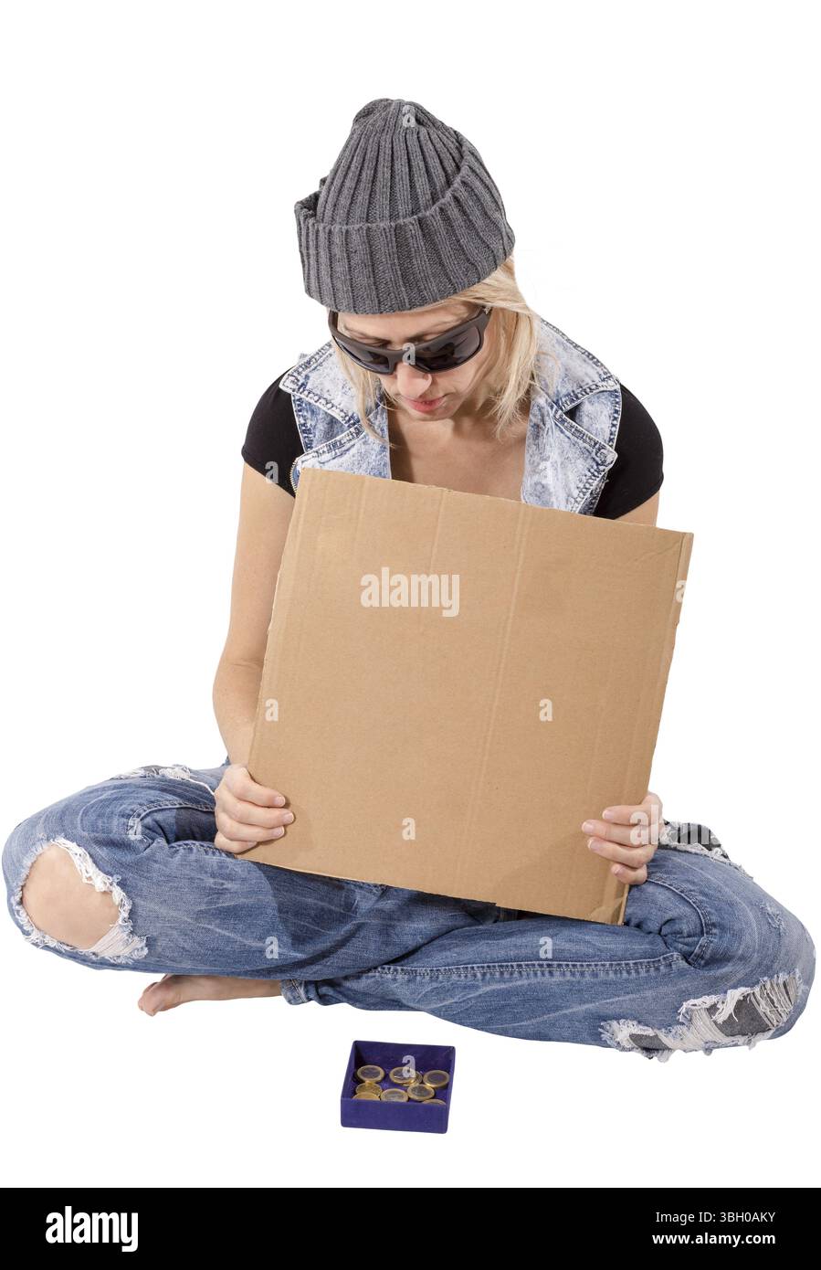 Sitting homeless woman is holding a blank cardboard while begging. Pure ...