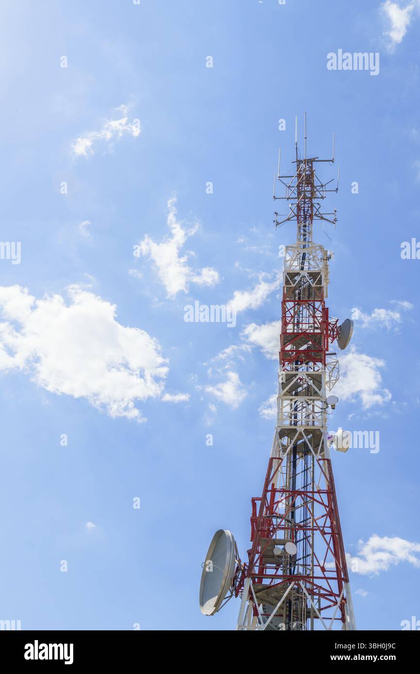 Telecommunication tower standing tall against a blue sky with white clouds Stock Photo - Alamy